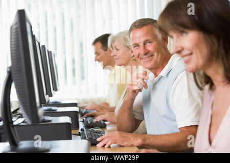 Four people sitting at computer terminals (depth of field/high key ...