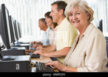 Four people sitting at computer terminals (depth of field/high key ...