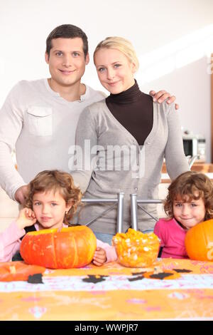Family gathered around kitchen table preparing pumpkins Stock Photo - Alamy