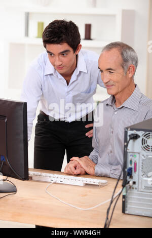 Grandson is teaching his grandfather to use laptop computer Stock Photo ...
