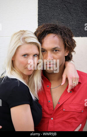 Husband and wife leaning against stone wall Stock Photo - Alamy