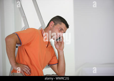 Man making telephone next to step-ladder Stock Photo - Alamy