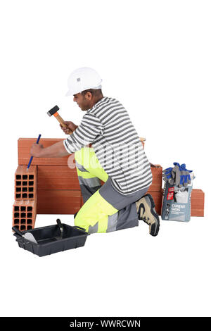 Man chiseling away at brick Stock Photo - Alamy