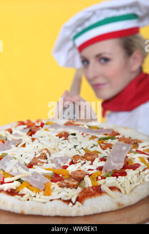 Pretty cook woman with ham pizza on white background Stock Photo - Alamy