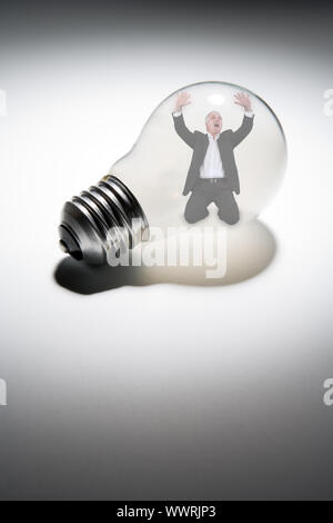Businessman trapped in bulb Stock Photo - Alamy