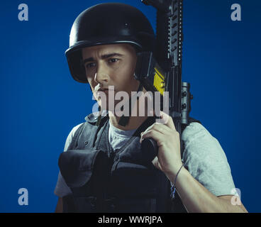 Airsoft sport player wearing protective helmet aiming pistol, black ...