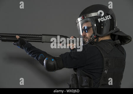 Riot police in full combat gear on standby in the town plaza during ...