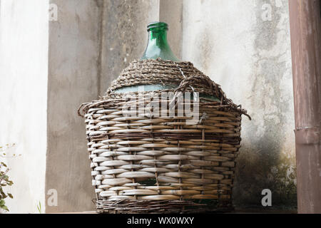Empty carboy in rustic house, leaning against the wall Stock Photo - Alamy