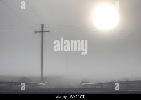 A photo of an early morning filled with fog at a country road in ...