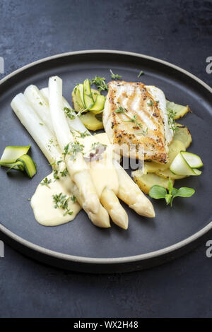 Modern German fried cod fish filet with white asparagus tips and roast ...