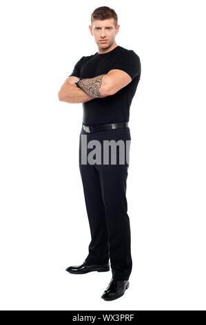 Tough serious bouncer or bodyguard with crossed arms staring at camera ...