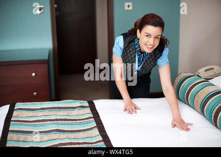 Casual shot of cheerfully working housekeeping employee Stock Photo - Alamy