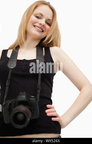 Joyful woman carrying a camera against white background Stock Photo - Alamy