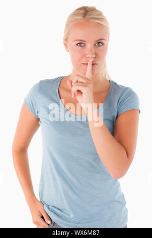 Hushing blond woman Stock Photo - Alamy