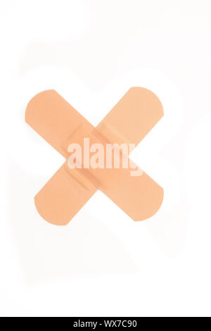 Two plasters crossed on white background Stock Photo - Alamy
