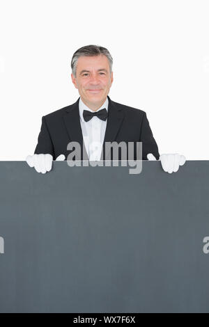 Waiter standing behind grey sign Stock Photo - Alamy