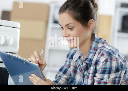 laundry worker taking notes about broken machine Stock Photo - Alamy