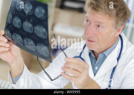 Senior man doctor examines MRI image of human head in hospital Stock ...