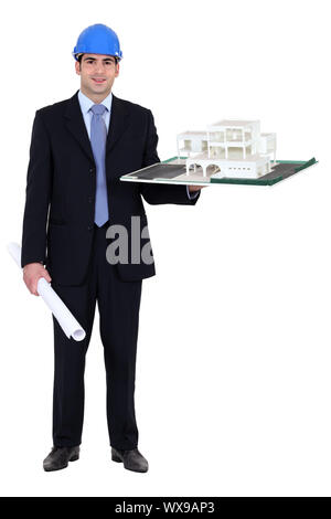 Architect presenting model of modern house to client in office Stock ...