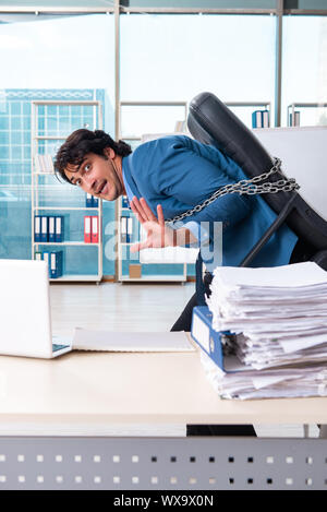 Chained employee unhappy with excessive work in the ofiice Stock Photo ...