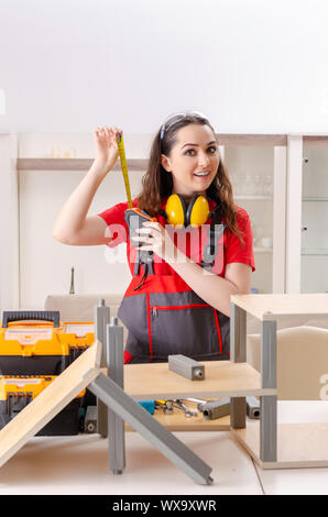 female furniture worker measuring chair leg Stock Photo - Alamy