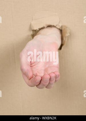 Man is showing his fingers through a hole in white paper Stock Photo ...