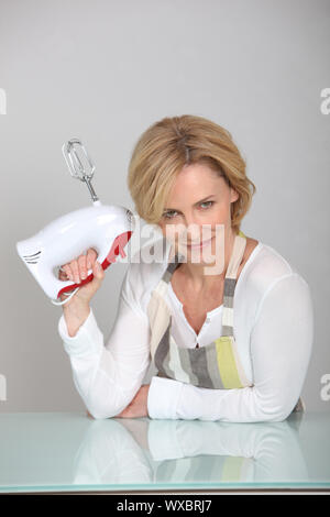 Woman with an electric whisk Stock Photo - Alamy
