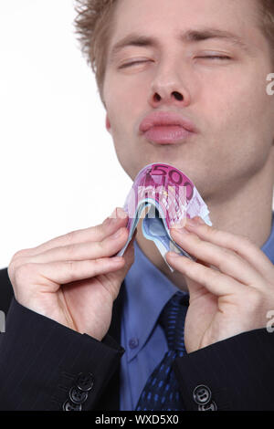Young hispanic man holding euro banknotes looking positive and happy ...