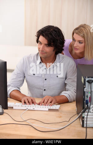 Man helping colleagues with computer issue Stock Photo - Alamy