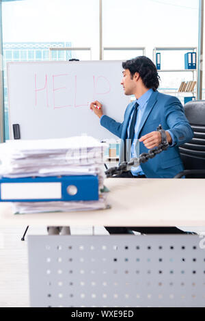 Chained employee unhappy with excessive work in the ofiice Stock Photo ...