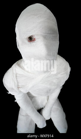 Mummy with open one eye on the black background Stock Photo - Alamy