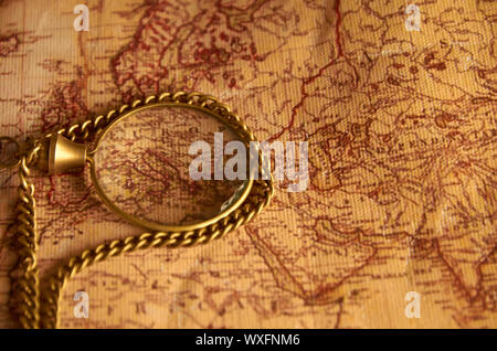 Old gold magnifying glass lying on a map Stock Photo - Alamy