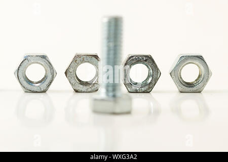 four screws standing behind one screw on white background Stock Photo ...
