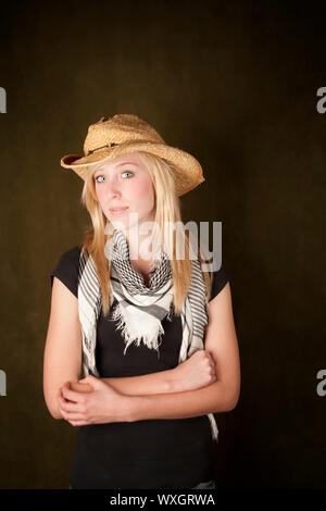 Happy blonde girl wearing a straw hat standing in a vast lavender field ...