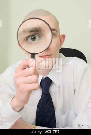 The guy looks through the big magnifier Stock Photo - Alamy