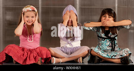 Three kids in the classic denial of evil pose Stock Photo - Alamy