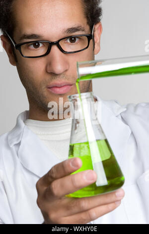 African american man scientist pouring liquid on test tube at ...