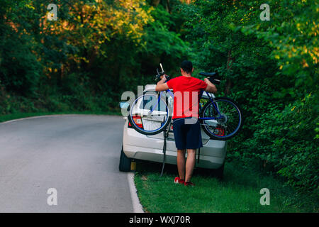 Tired (exhausted) biker puts his bike on a car to get a ride Stock ...