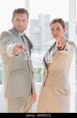 Serious business team pointing at camera Stock Photo - Alamy