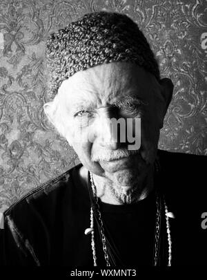 Senior tough guy in green knit cap leaning Stock Photo - Alamy