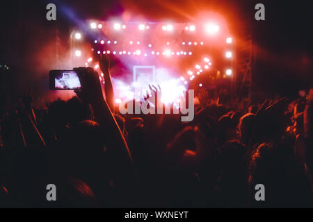 People taking photographs with touch smart phone during a music ...