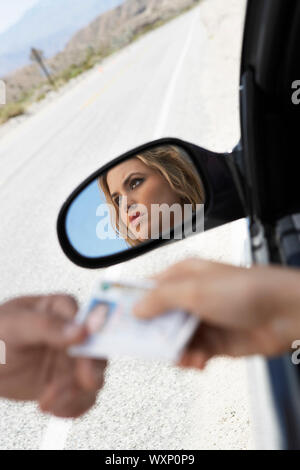 Police officer handing drivers license to man in Mustang Stock Photo ...