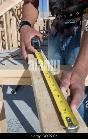 man measuring half constructed wall with tape measure Stock Photo - Alamy
