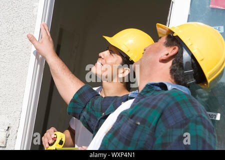 Construction Workers examining window frame Stock Photo - Alamy