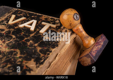 Inscription vat old rubber stamp. Office accessories on a dark table ...