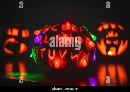 three carved pumpkins with a candle for halloween Stock Photo - Alamy