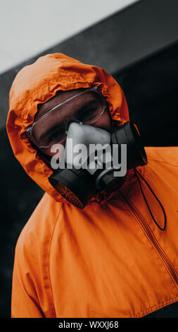 Industrial painter in respirator and helmet paints metal fence from ...