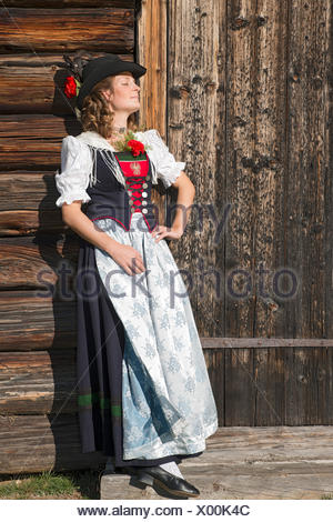 Young woman in Tyrolean costume in front of mountain backdrop, Pitztal ...