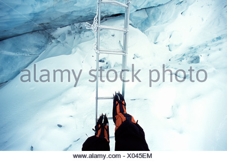 A climber on Mount Everest crossing a crevasse on a ladder in the Stock ...