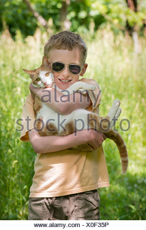 Portrait of boy holding cat , outside.With MR Stock Photo - Alamy